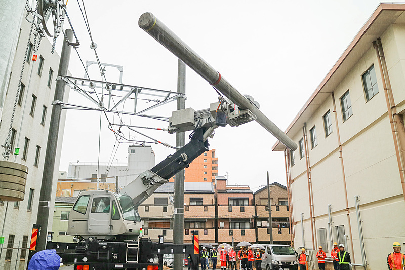 Jr西日本、電柱をアームでつかんで設置する「電柱ハンドリング車」公開。軌道走行も可能 デモンストレーションを動画で紹介 トラベル Watch